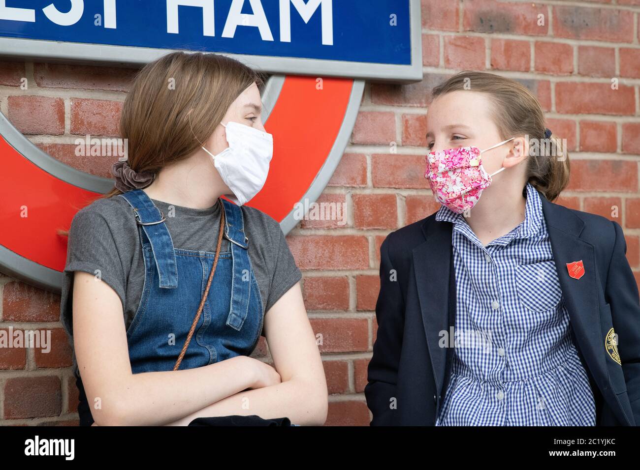 Children wearing facemasks on public transport. West Ham, Jubilee line ...