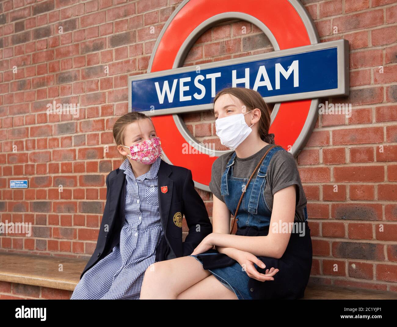 Children wearing facemasks on public transport. West Ham, Jubilee line ...