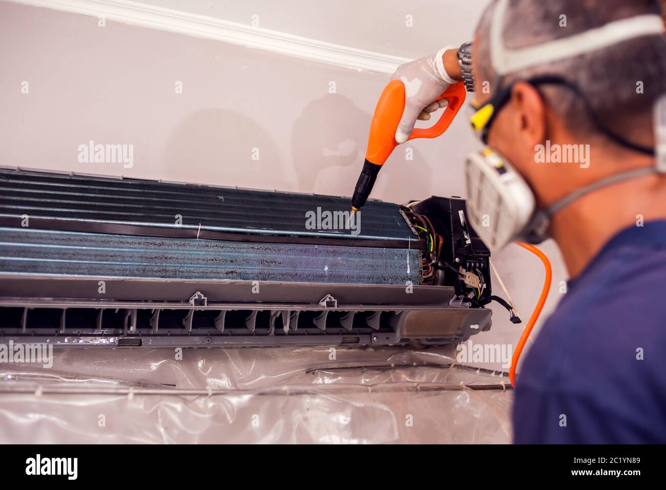 Man worker doing professional cleaning of air conditioning Stock Photo ...