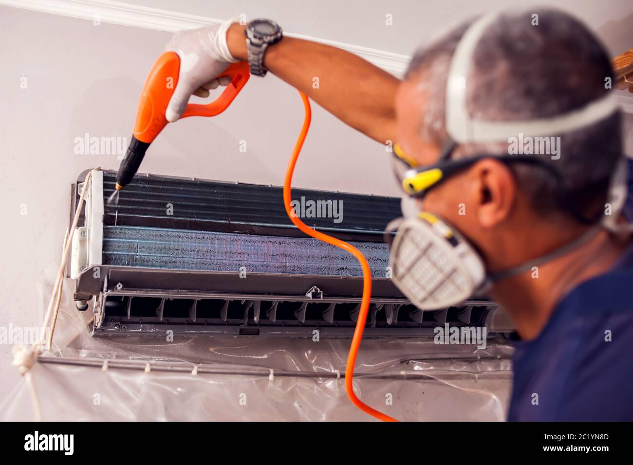 Man worker doing professional cleaning of air conditioning Stock Photo ...