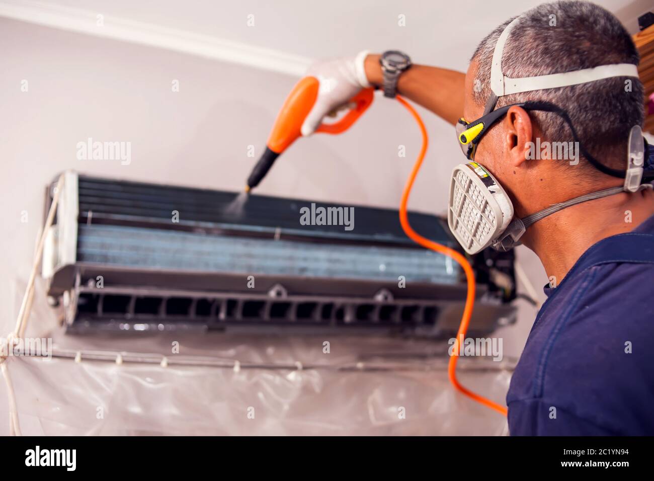 Man worker doing professional cleaning of air conditioning Stock Photo ...