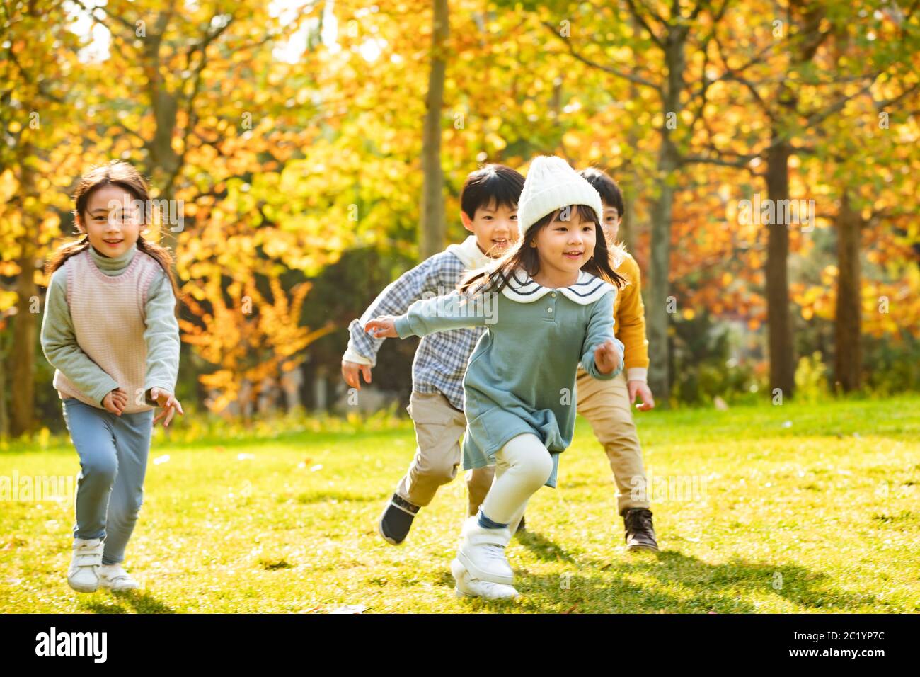 Happy children run on the grass Stock Photo - Alamy