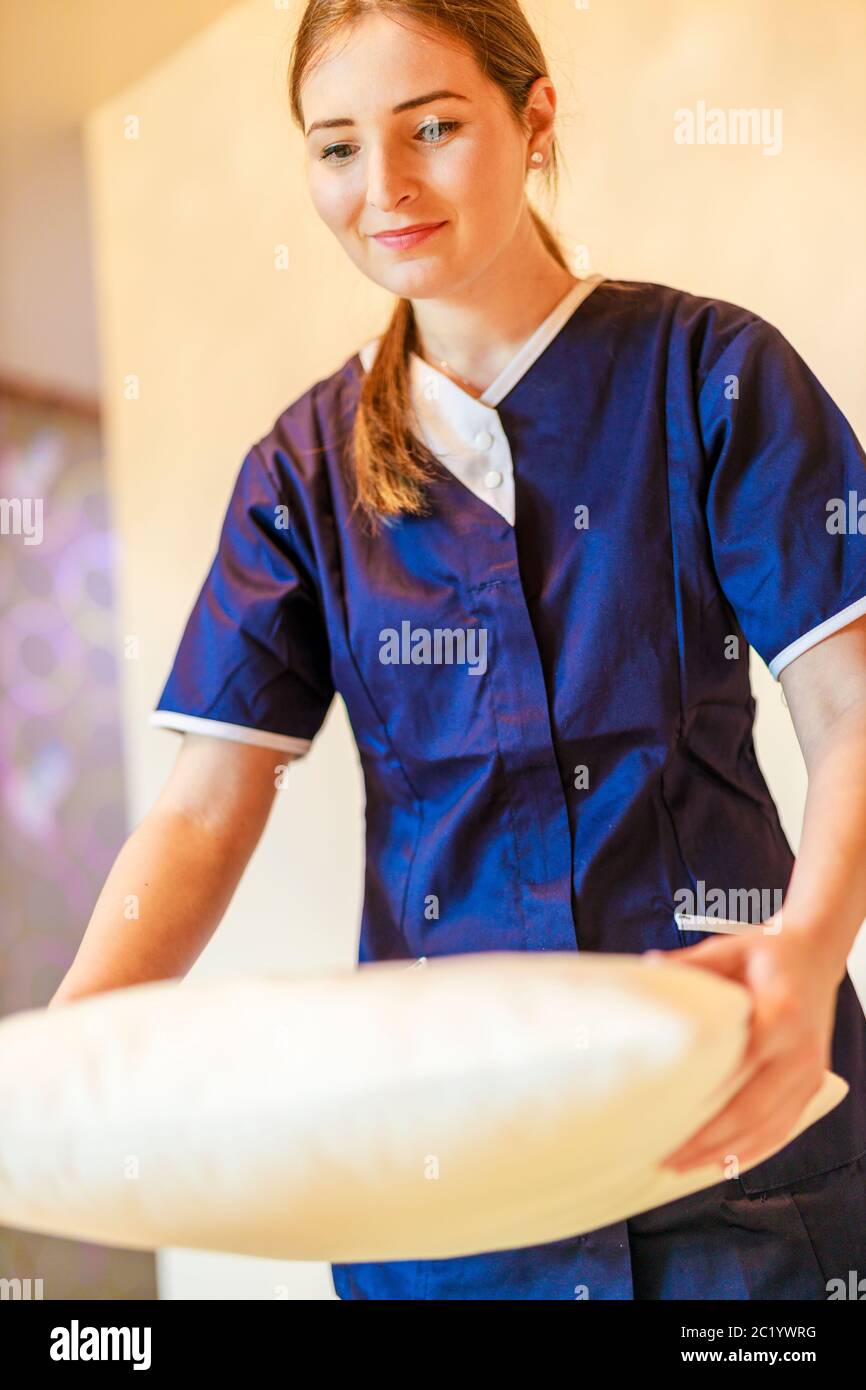 Maid in uniform making bed in hotel room Stock Photo - Alamy