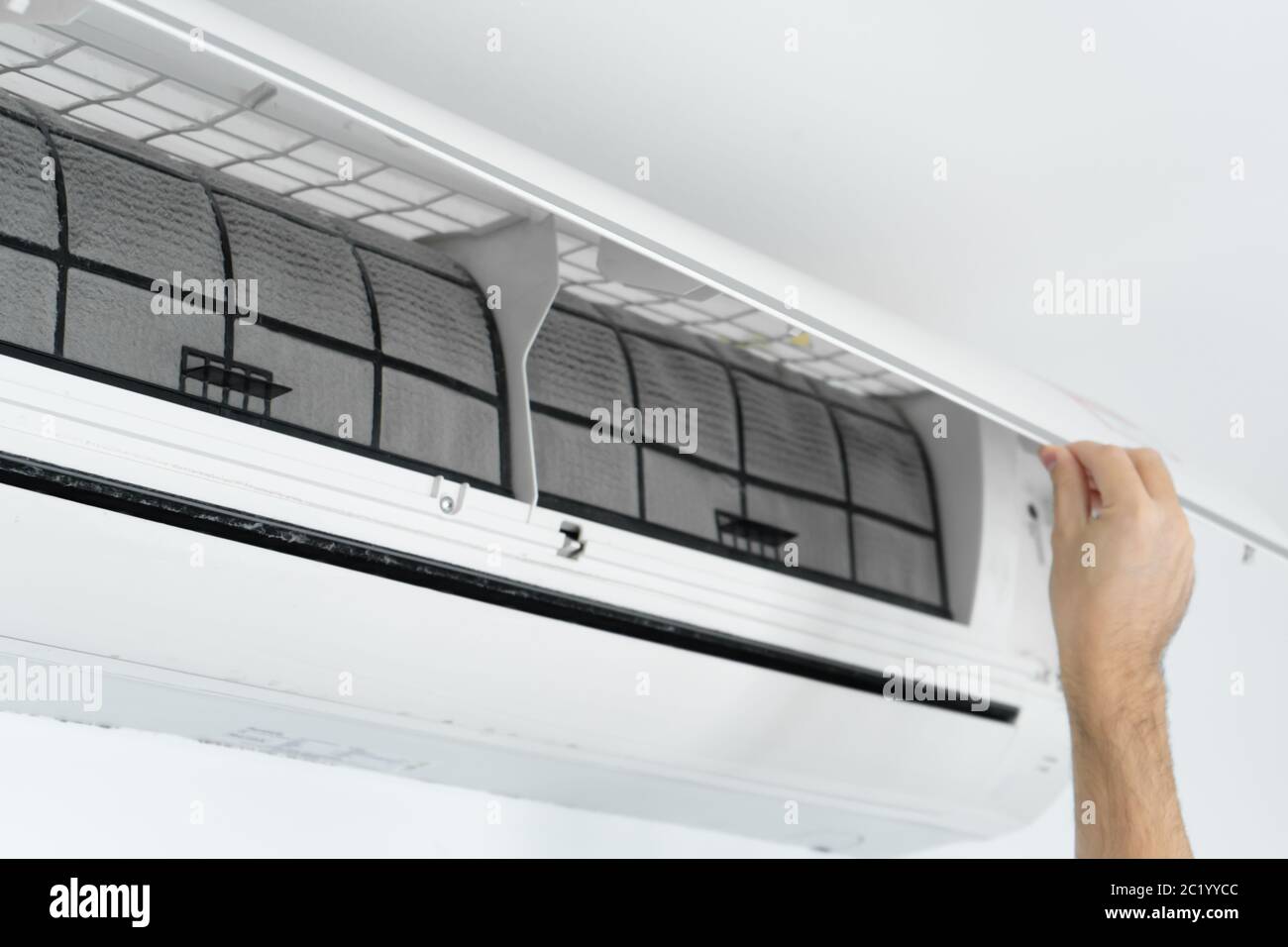 The guy cleans the filter of the home air conditioner from dust. Very ...