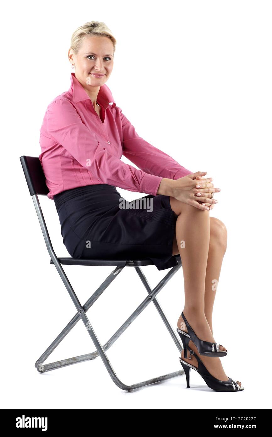 Portrait of mature realtor woman sitting on a black chair, on white ...