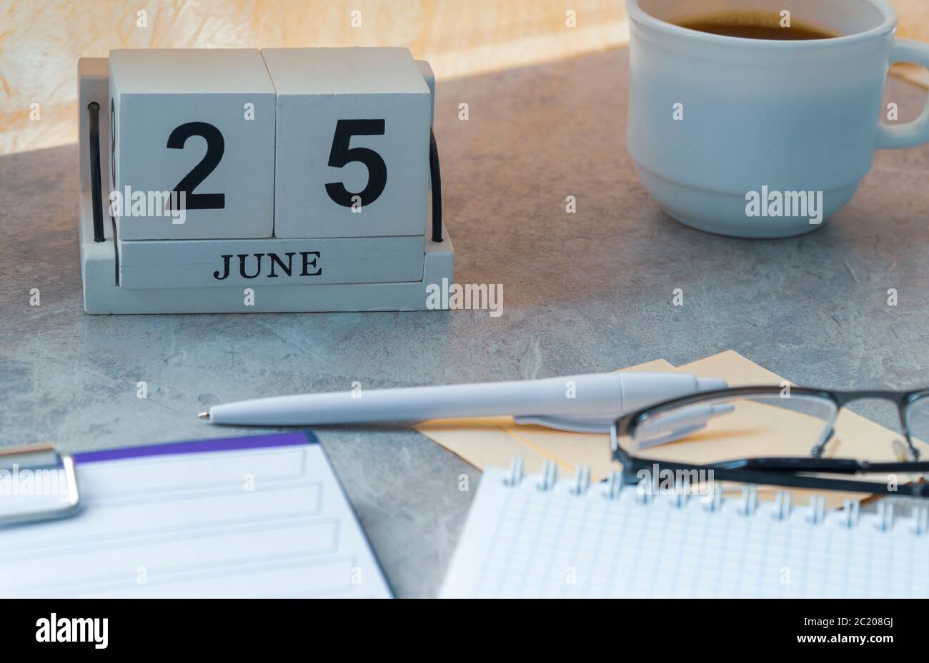 June 25, date on the calendar. Handmade wood cube with date month and ...