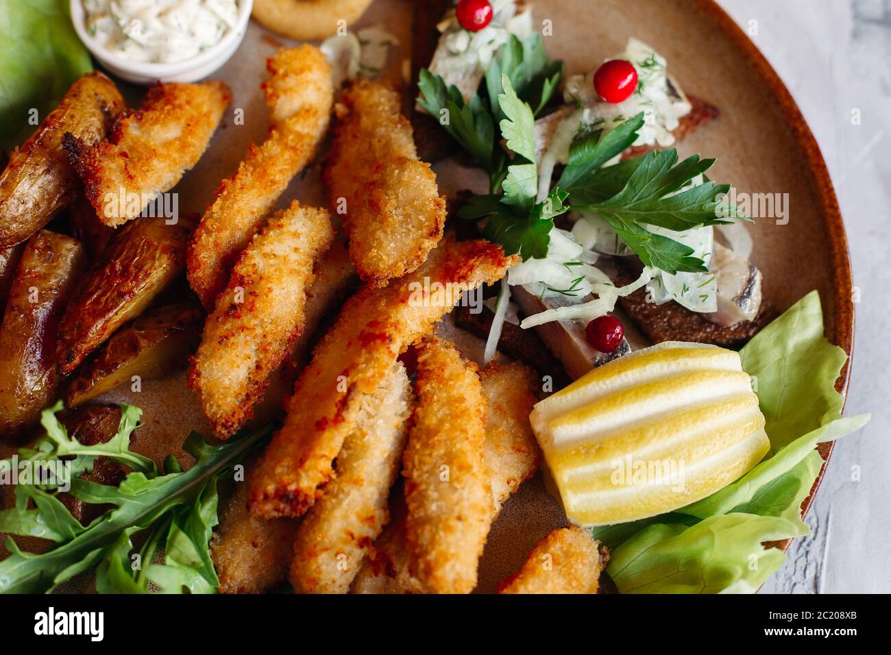 Clay plate full of delicious appetizers standing on white surface Stock ...