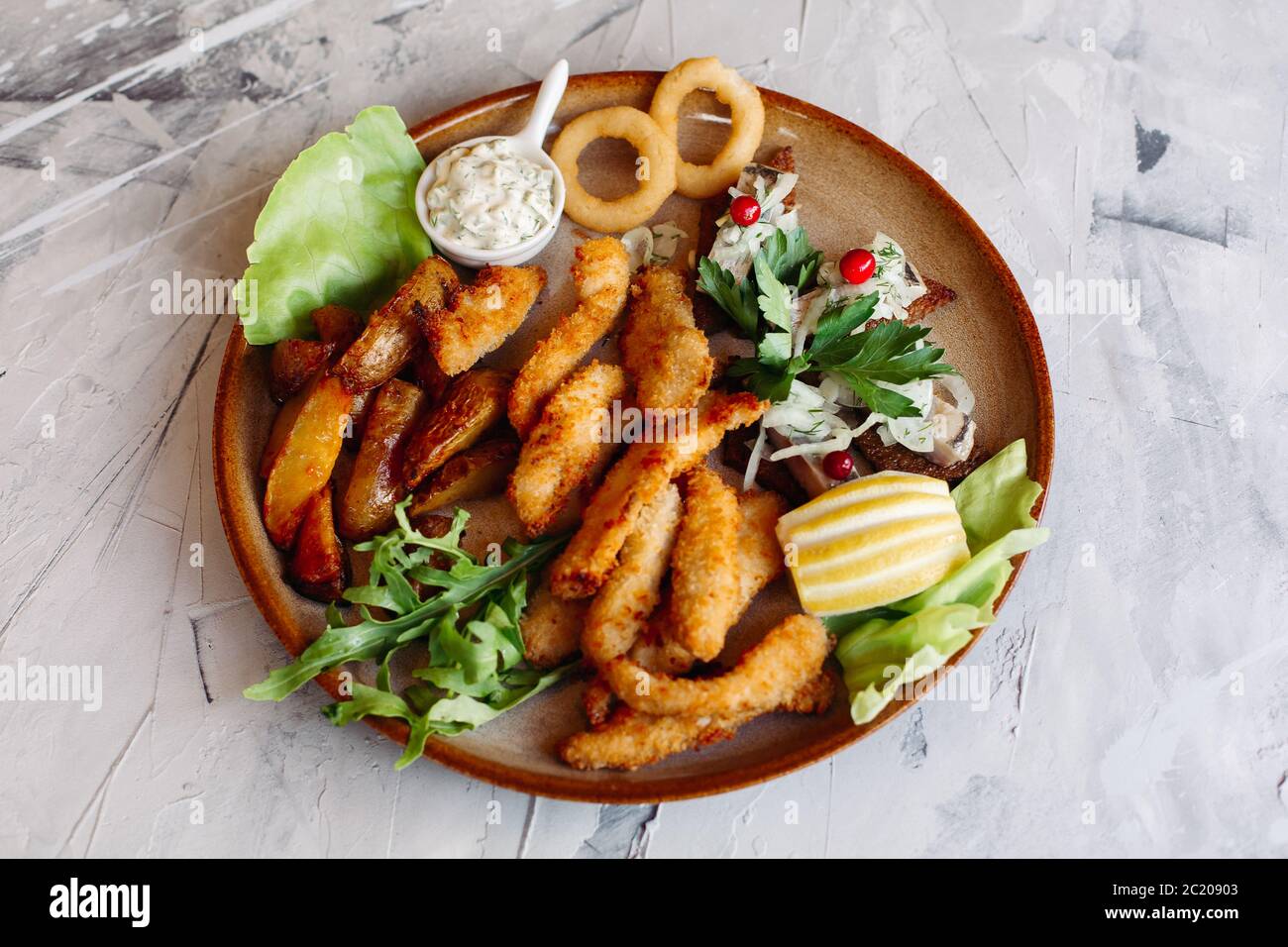 Clay plate full of delicious appetizers.garlic sauce, decorated with ...