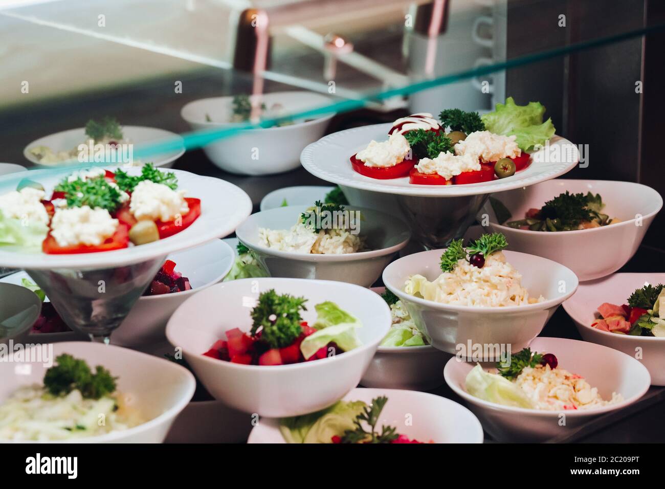 Many round plates with tasty vegetables dish of salads in restaurant ...