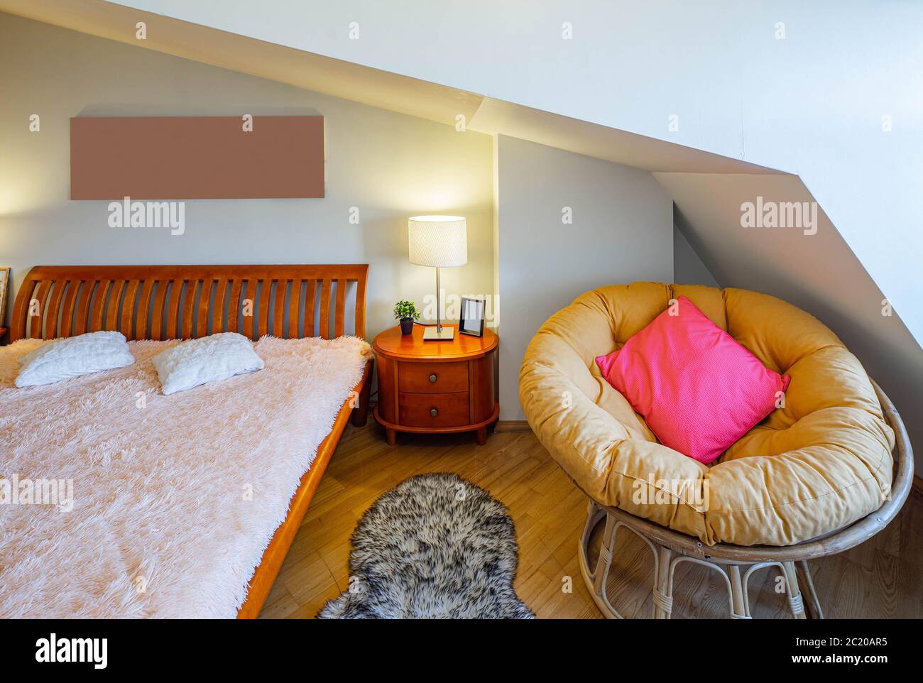 Wooden chair with pillows in the corner. Wooden bed and bedside with ...