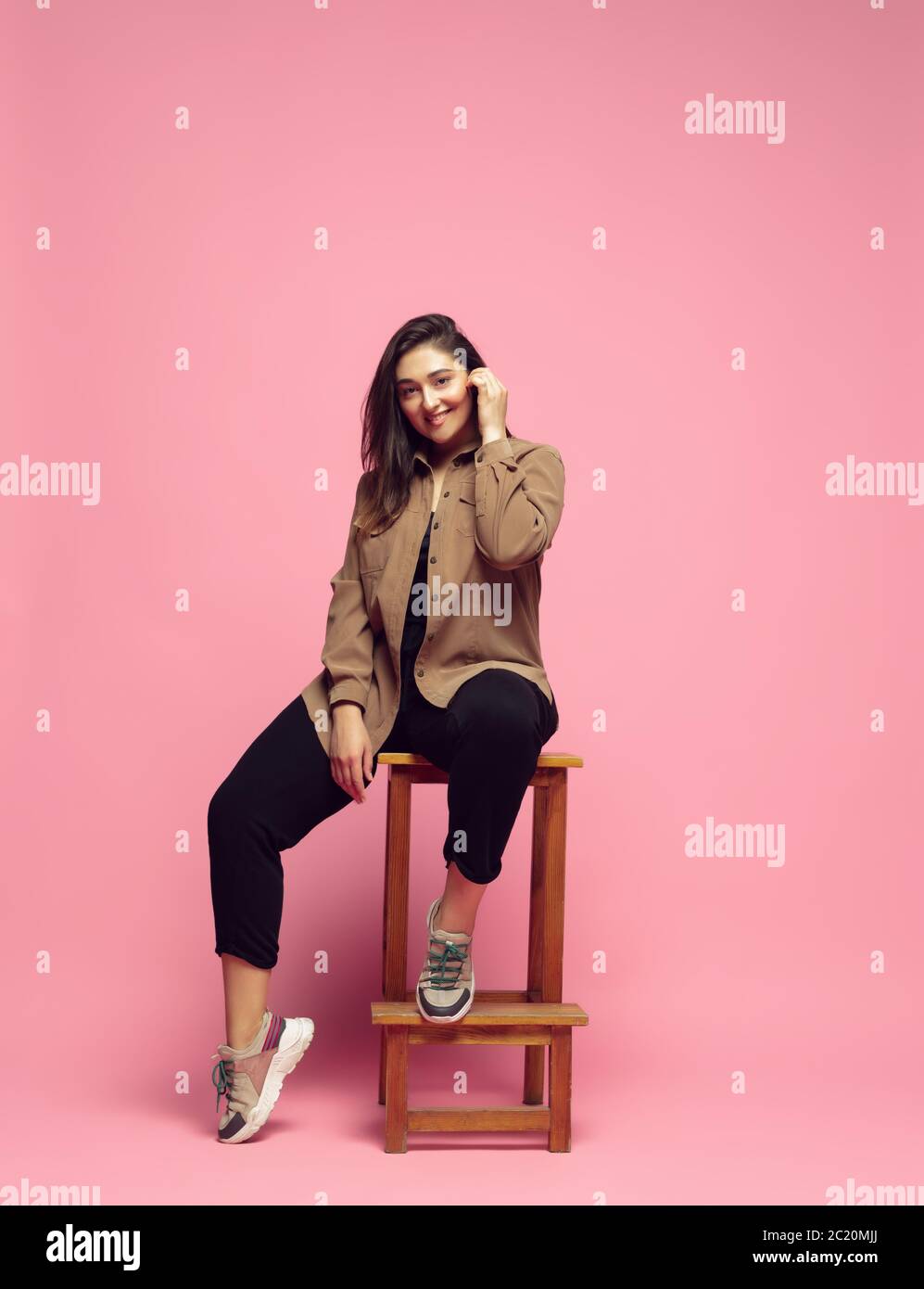 Posing stylish, elegance. Young woman in casual wear on pink background ...