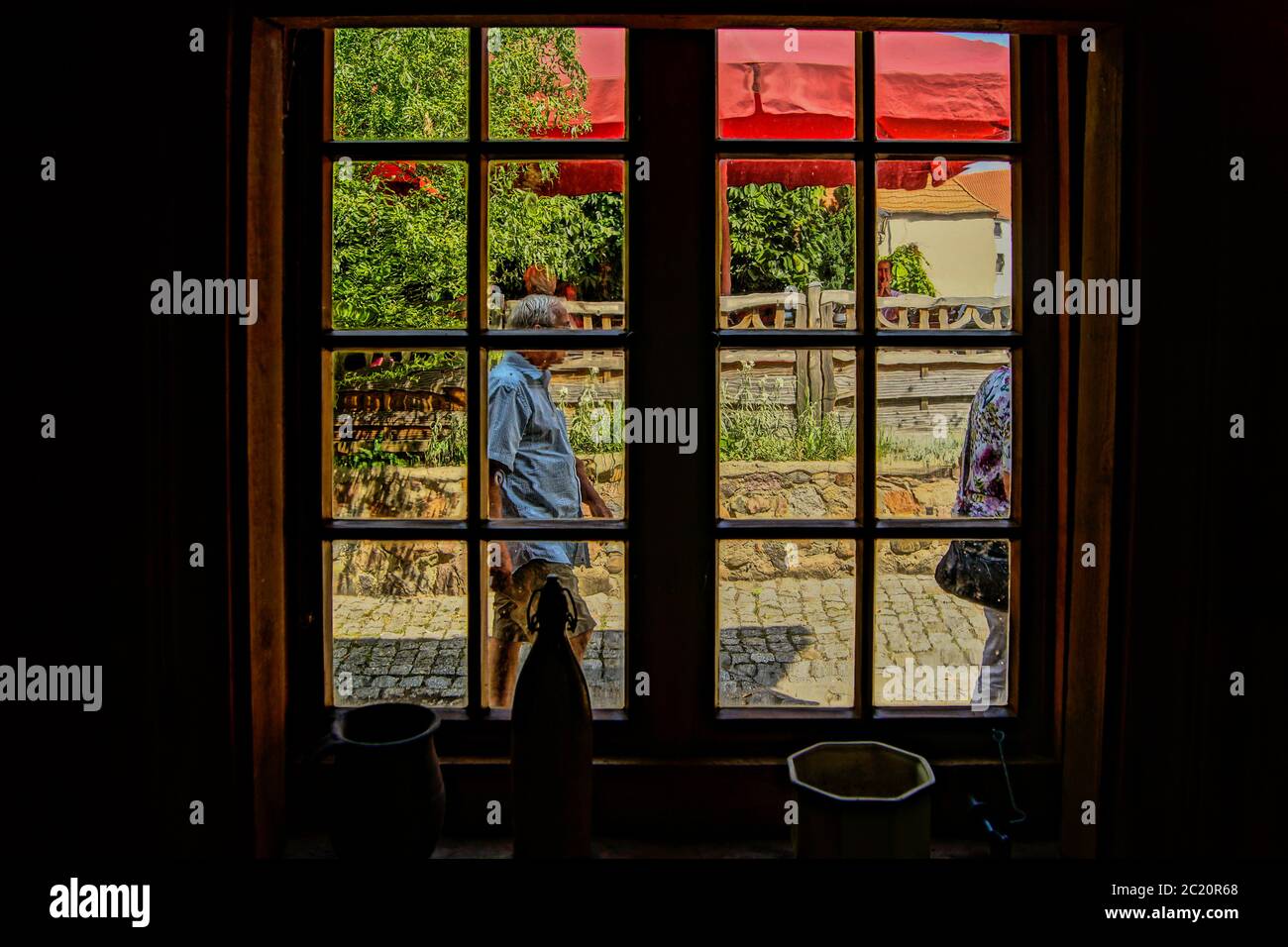 exterior view of an old medieval hut with an old man crossing in front ...
