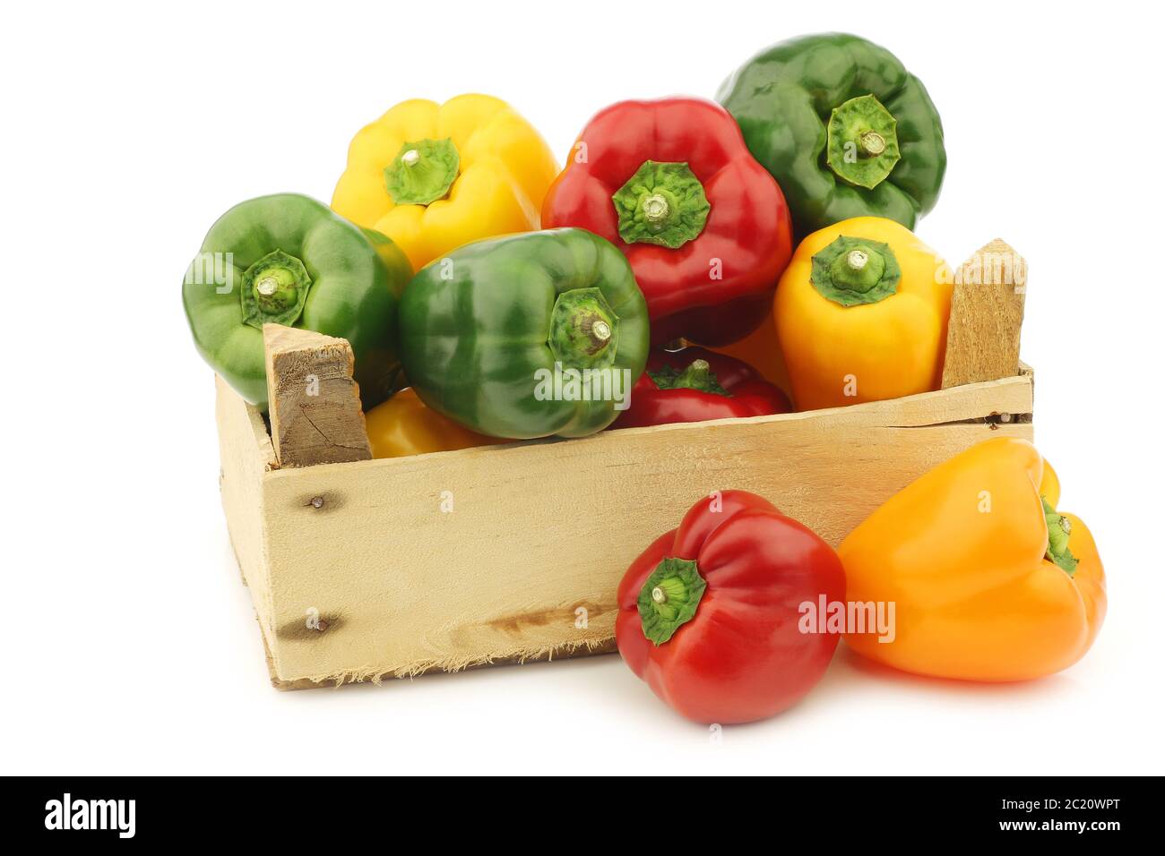 colorful mix of paprika's(capsicum) in a wooden box on a white ...