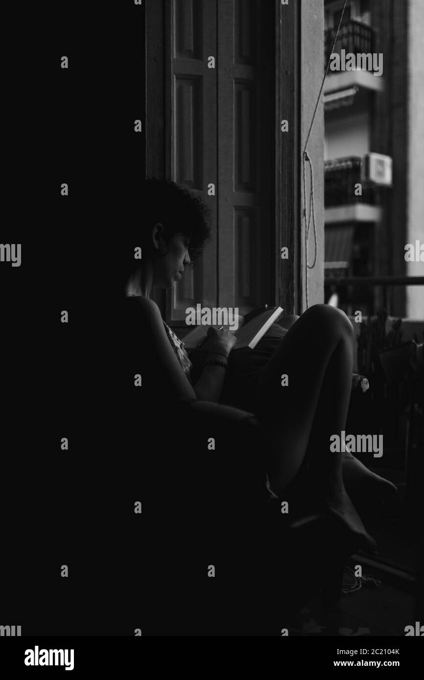 Woman portrait reading on the couch next to the window Stock Photo - Alamy