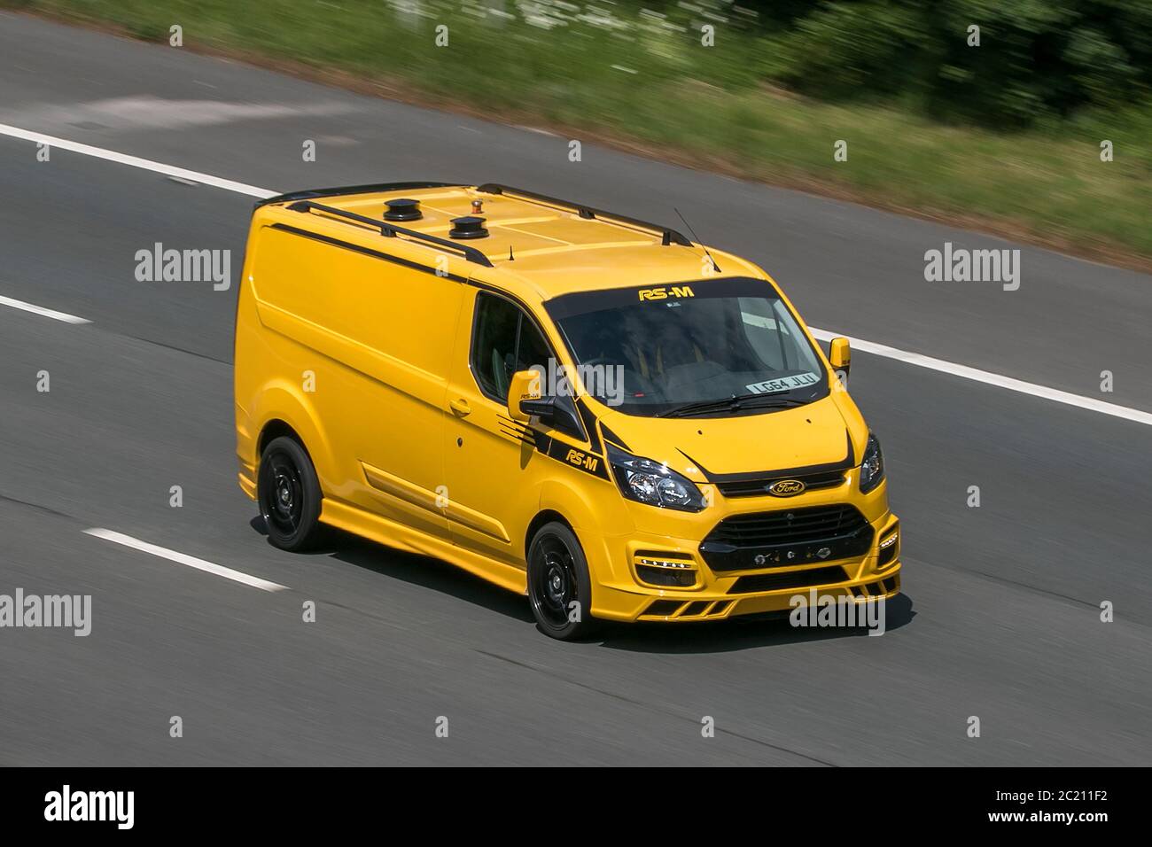A Ford Transit yellow panel van lcv driving on the M6 motorway near ...