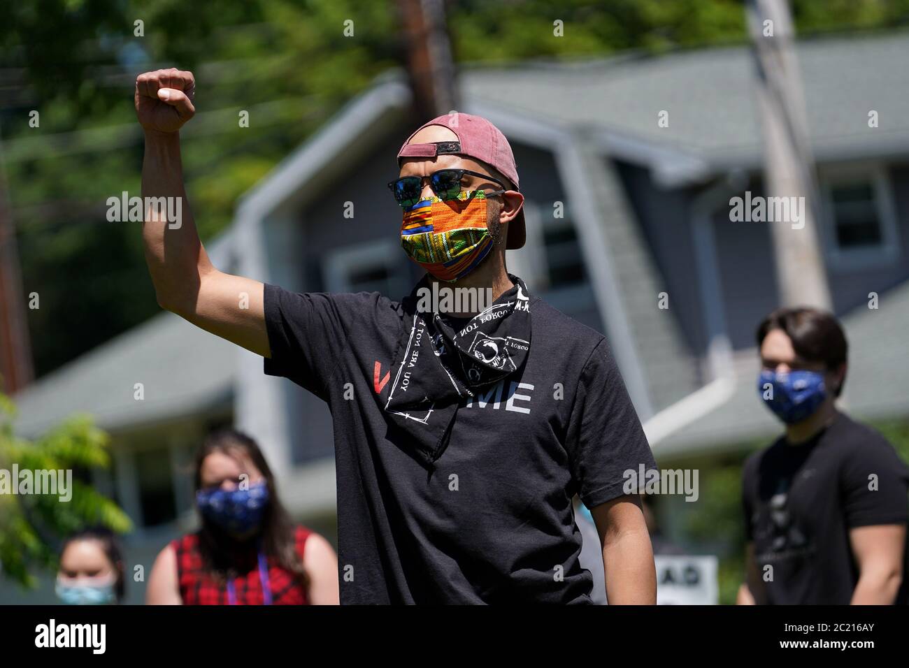 Event organizer Arthur Benson raises his fist as hundreds of community ...