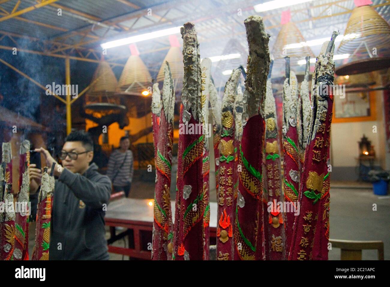 Man lighting incense sticks in Hong Kong temple Stock Photo - Alamy