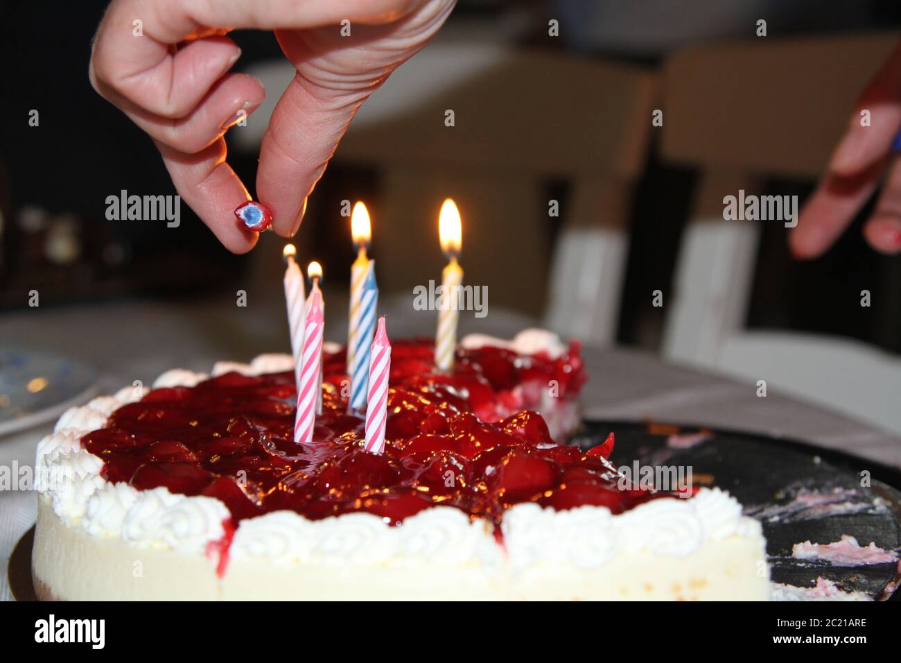 Hand holding candle over a cake Stock Photo - Alamy