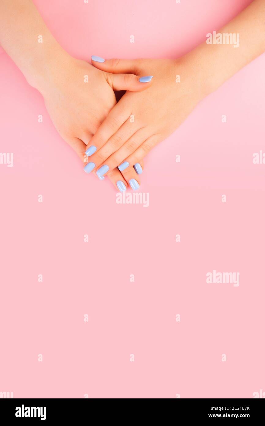 Hands of a beautiful woman on a pink background. Delicate hands with ...