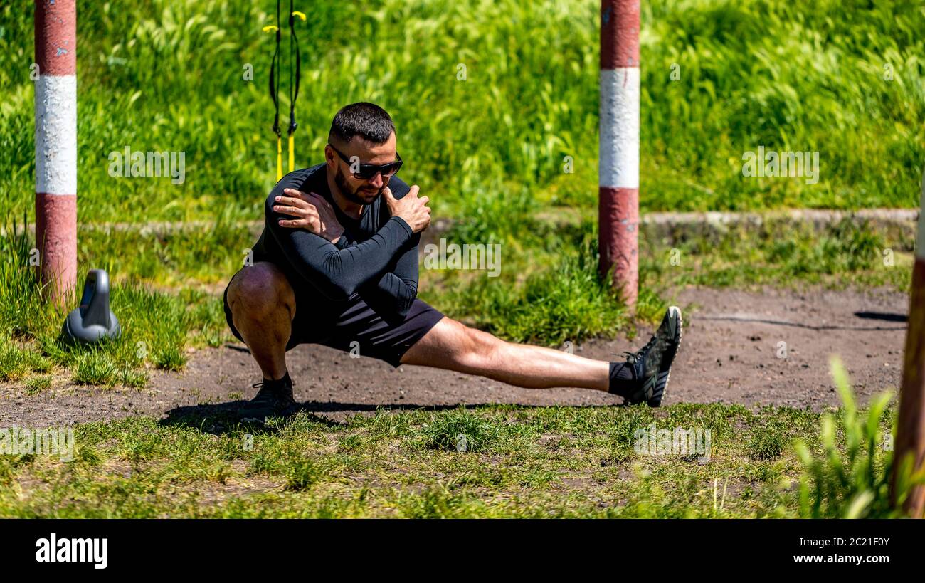 Fit man stretching outside, view at sea. Fitness and sport concept. Man ...