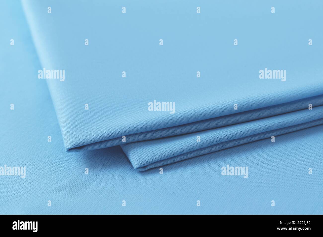 Side view of a stack of folded blue fabric with shallow depth of field ...