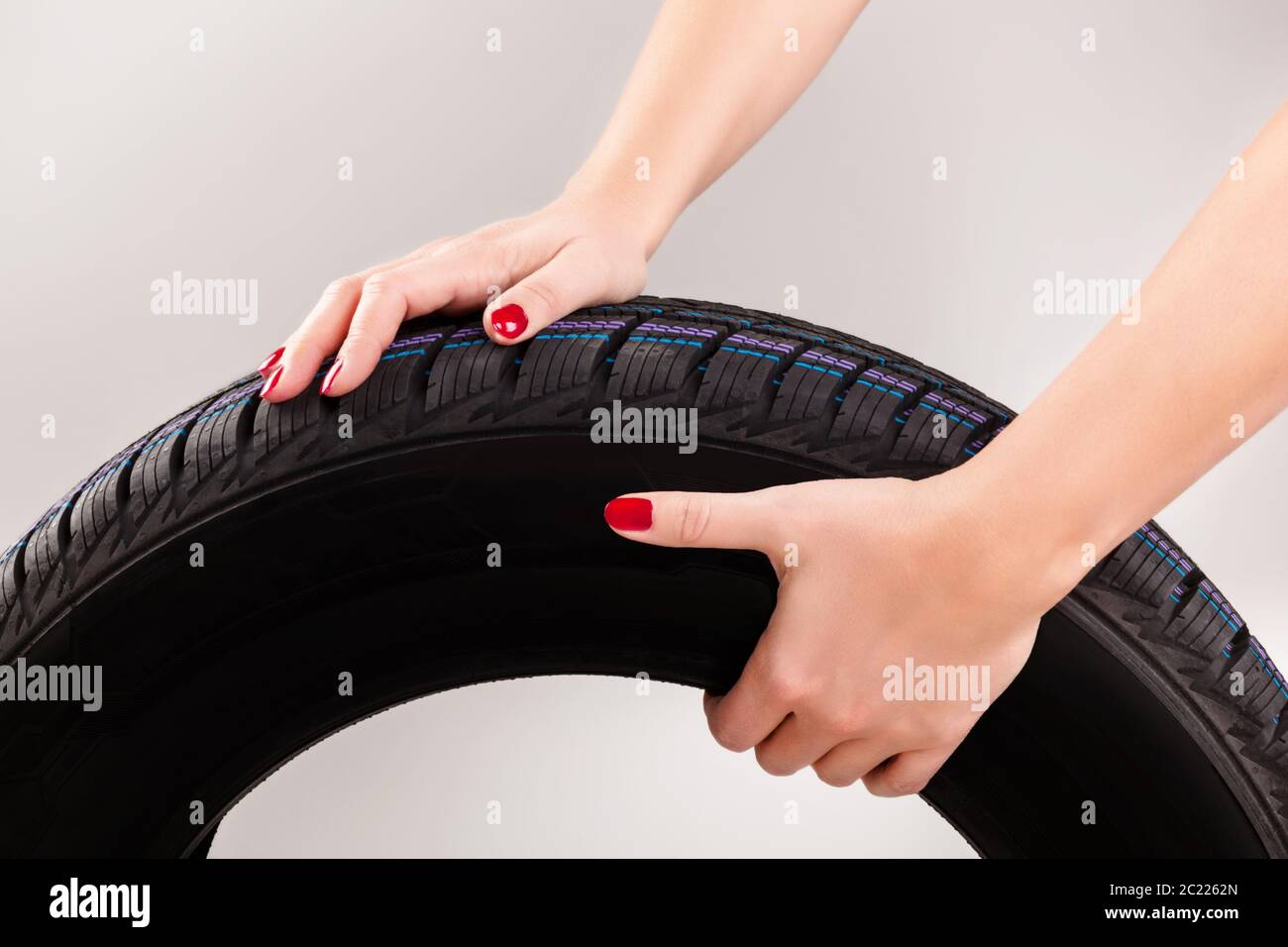 Woman hand holding car tire Stock Photo - Alamy