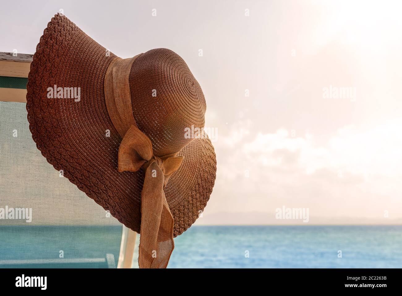 Female sunhat with ribbon on beach chair Stock Photo - Alamy