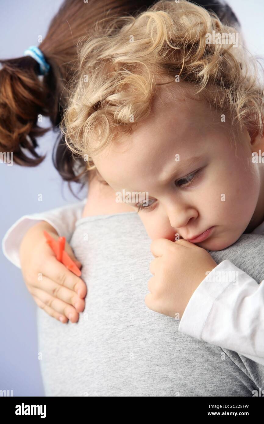 Sad child with plane on mothers hands. Warm hug from caring people ...