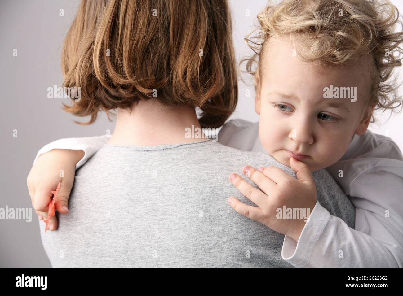 Sad child with plane on mothers hands. Warm hug from caring people ...