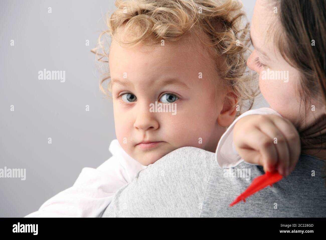 Sad child with plane on mothers hands. Warm hug from caring people ...