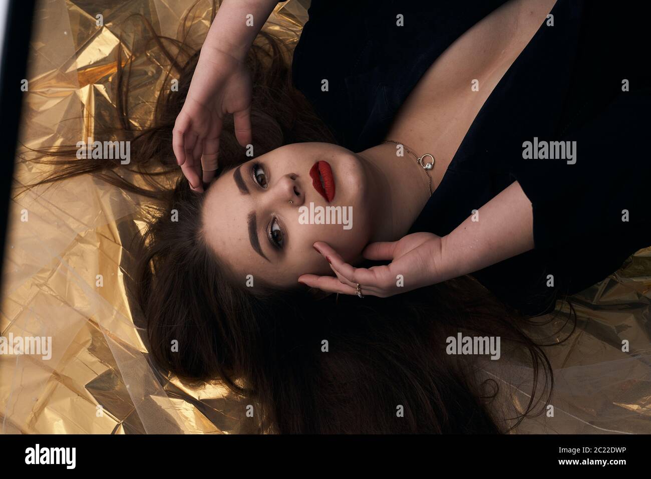 Beautiful makeup of a chubby girl lies on a gold foil Stock Photo - Alamy