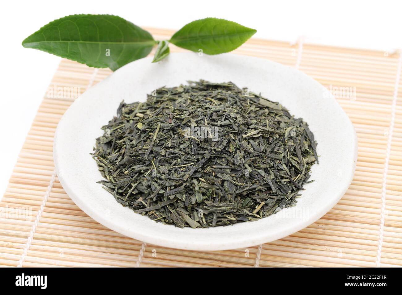 Dried tea leaves with green tea leaves on bamboo background Stock Photo ...