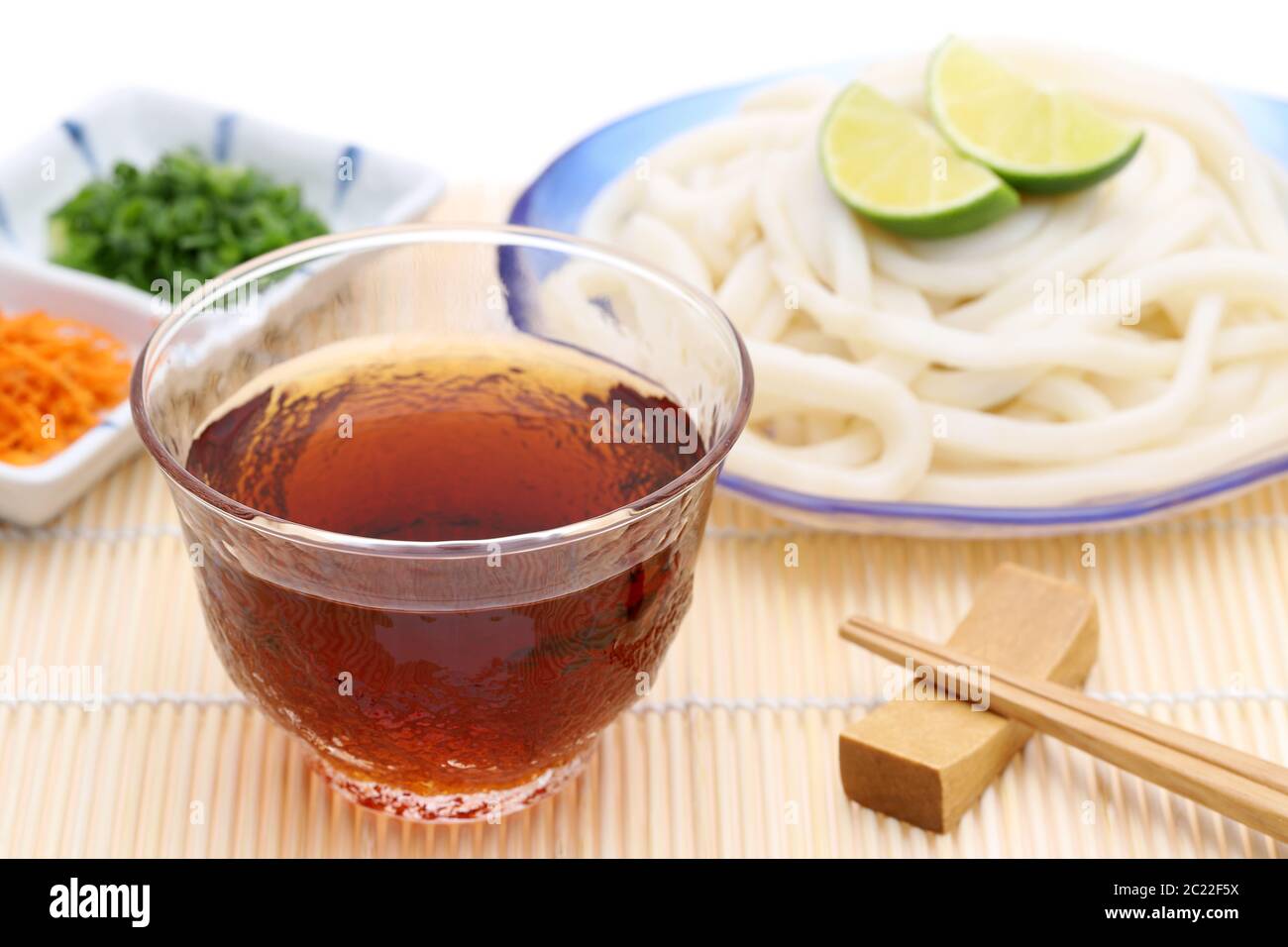 Japanese chilled udon noodles in a glass plate with soy sauce on white ...
