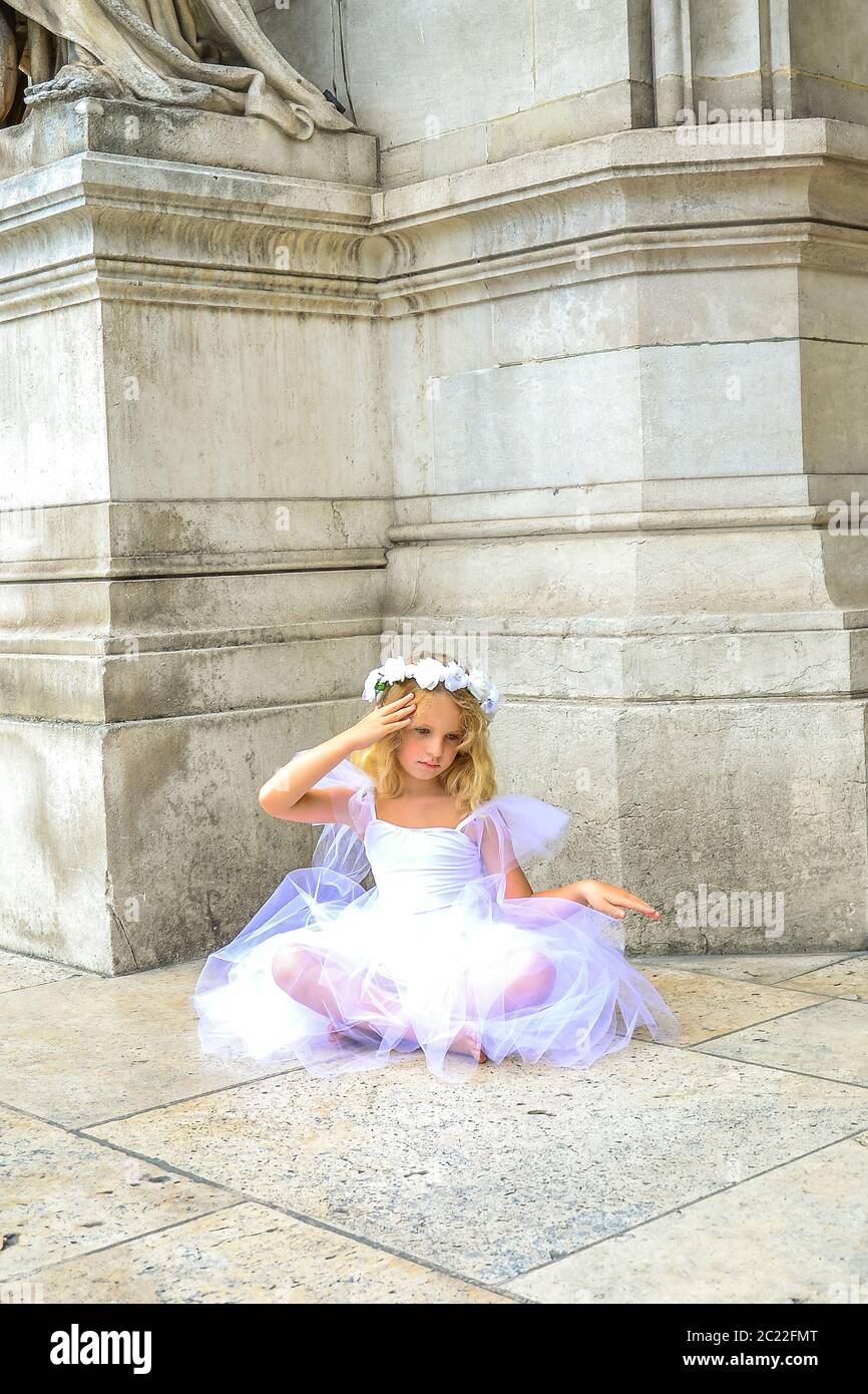 Girl ballerina Paris sitting on a old stone background. Beautiful model ...