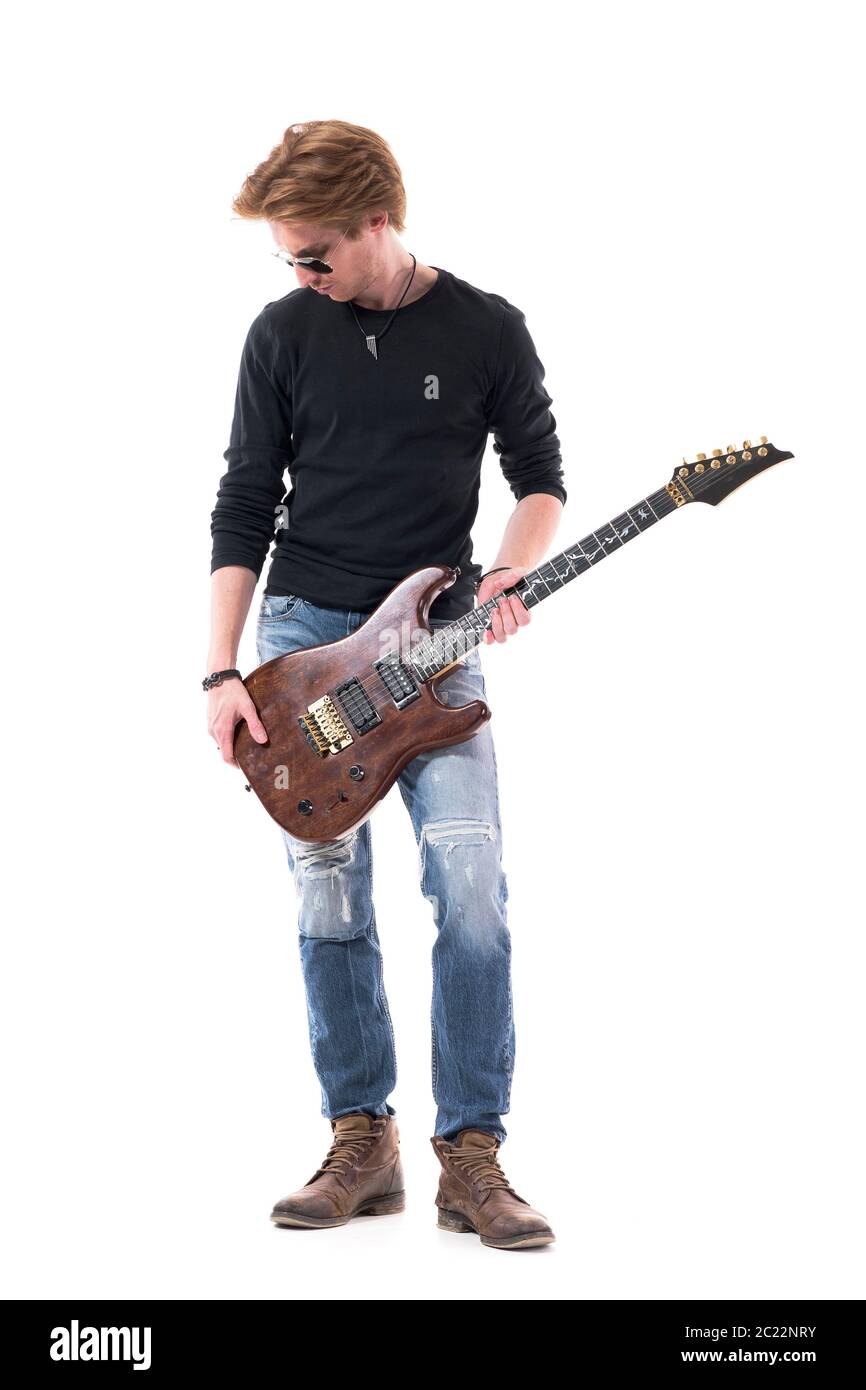 Young stylish ginger rock musician getting ready for playing holding ...
