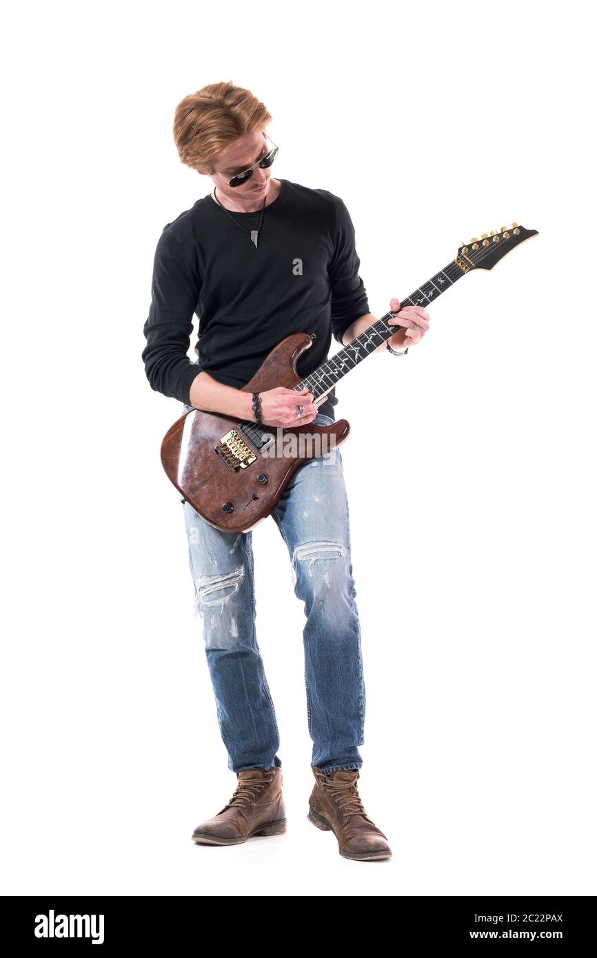 Cool relaxed young stylish handsome rocker man practicing or rehearsing ...