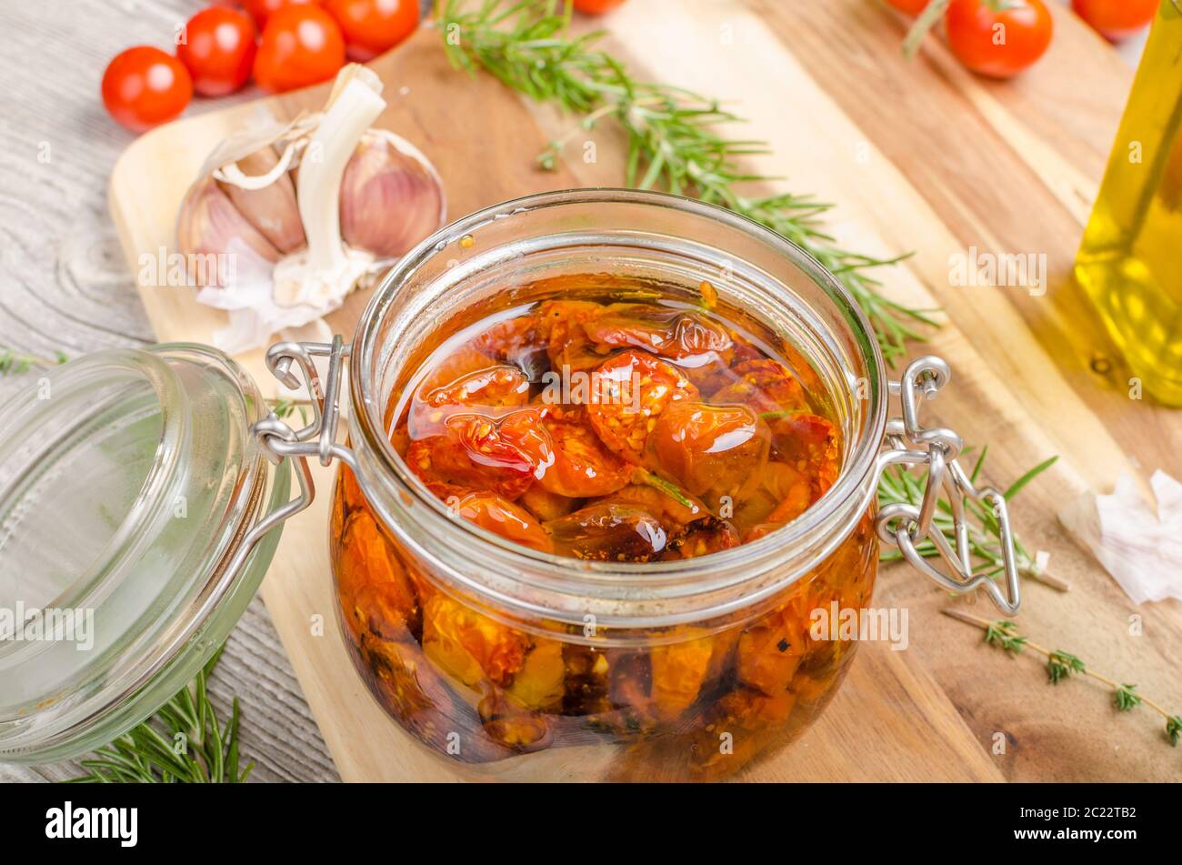 Homemade sun dried tomatoes, with olive oil, garlic and herbs, dried in ...