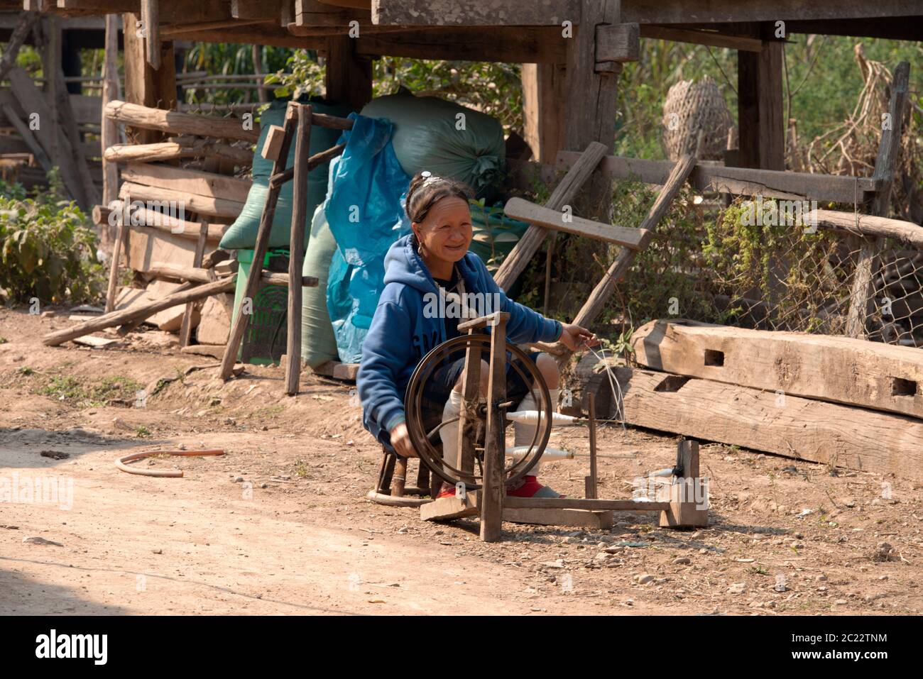 An elderly, indigenous, ethnic Lanten lady spinning yarn in her village ...