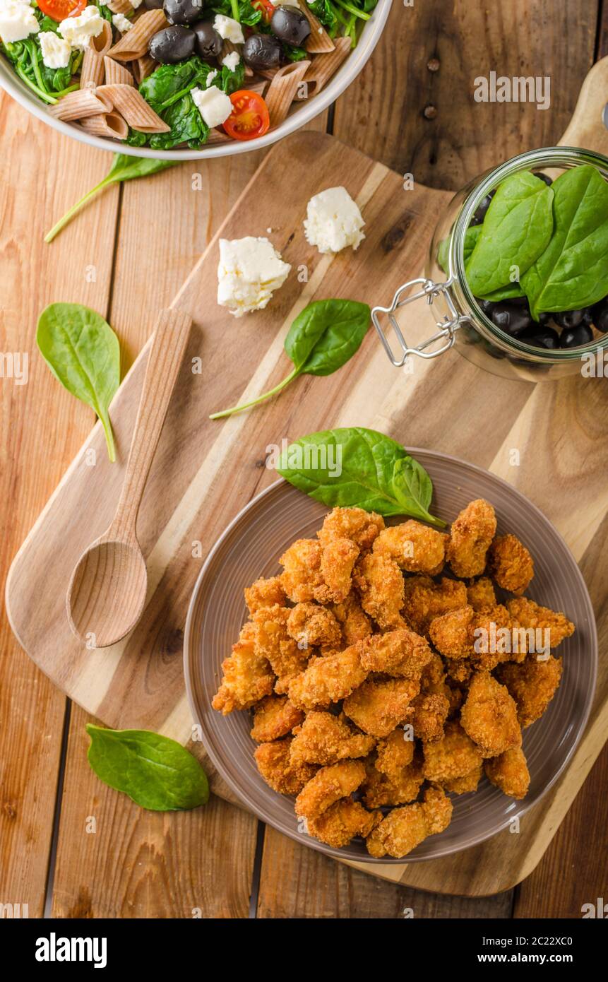 Chicken delicious homemade popcorn, greek salad behind Stock Photo - Alamy