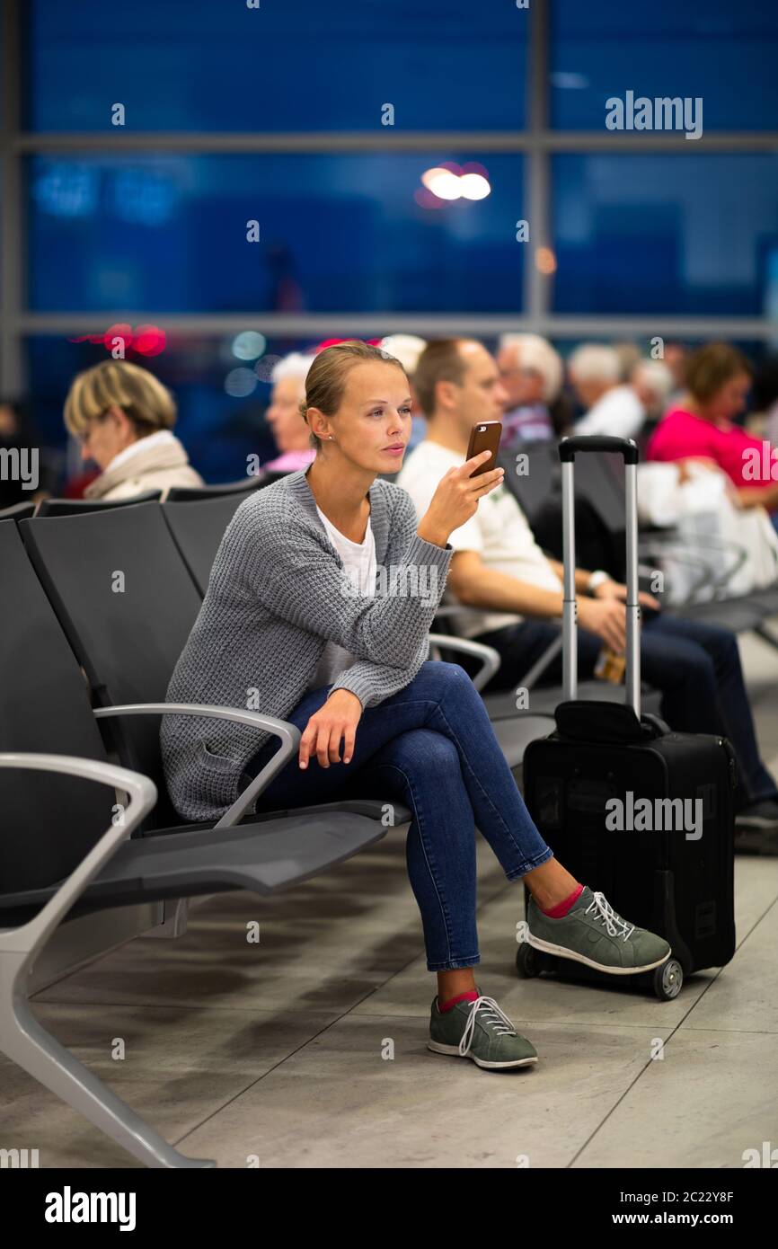 Young woman with her luggage at an international airport, before going ...