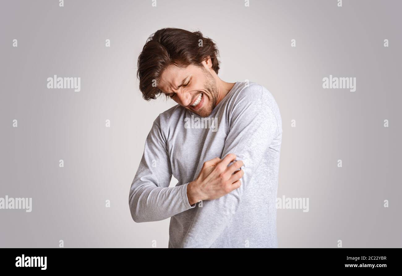 Allergic reaction. Man scratches his hand with force and suffers from ...