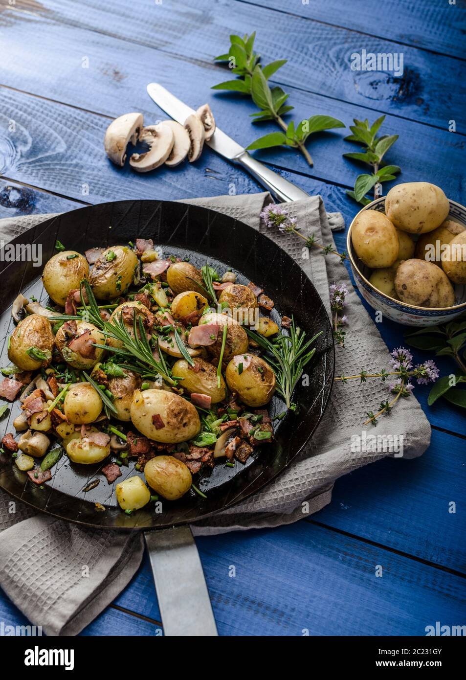 Sauteed new potatoes with bacon and herbs Stock Photo - Alamy