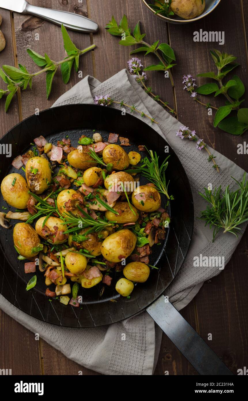 Sauteed new potatoes with bacon and herbs Stock Photo - Alamy