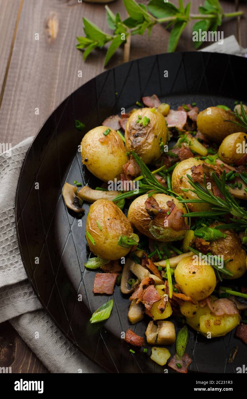 Sauteed new potatoes with bacon and herbs Stock Photo - Alamy