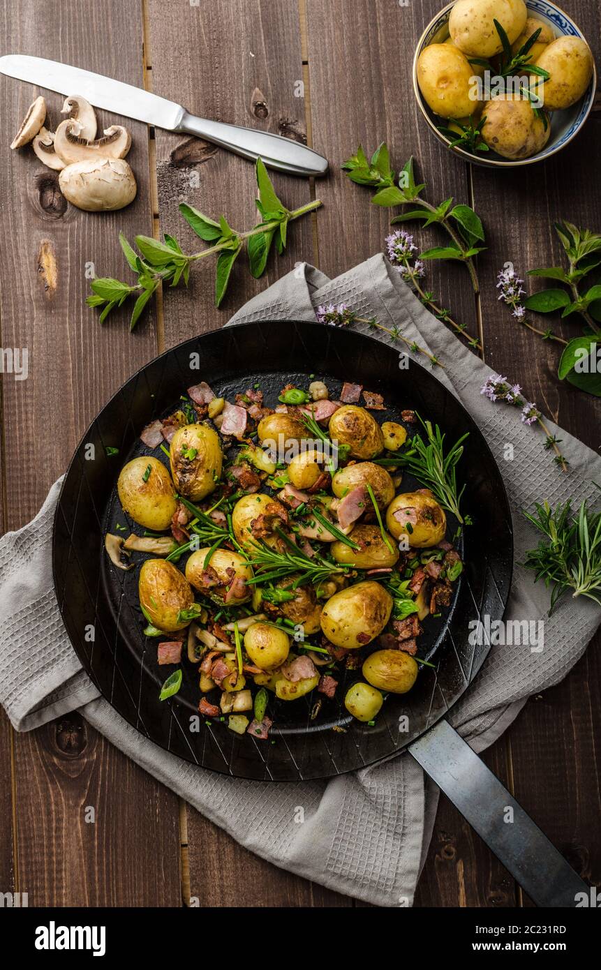 Sauteed new potatoes with bacon and herbs Stock Photo - Alamy