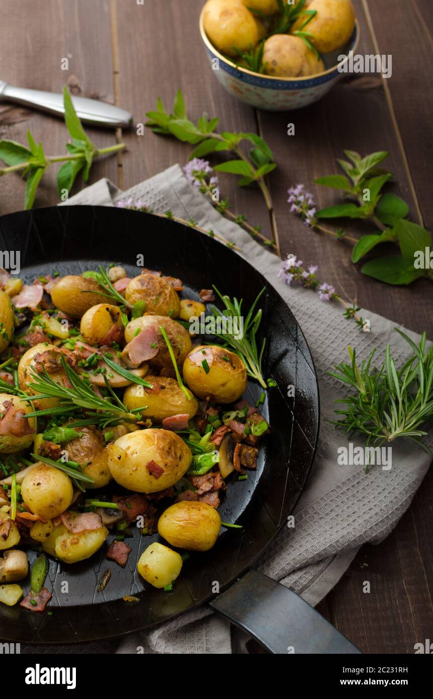 Sauteed new potatoes with bacon and herbs Stock Photo - Alamy