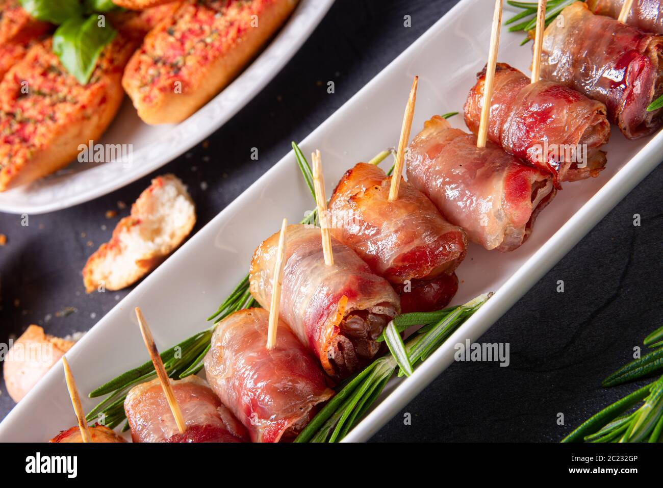 dates wrapped in bacon and delicious tapas Stock Photo - Alamy
