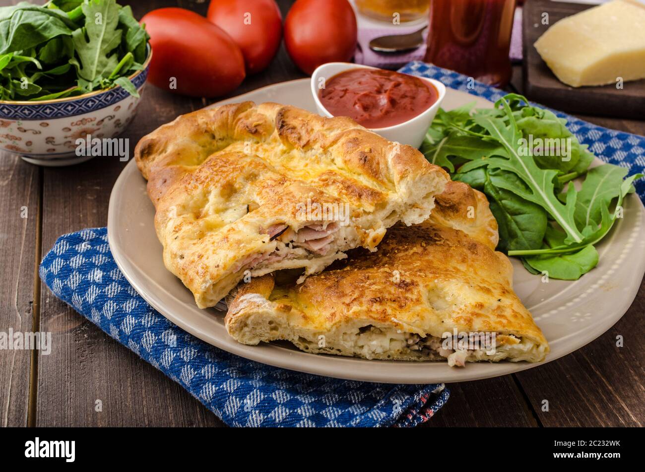 Calzone pizza stuffed with cheese and prosciutto, hot dip and summer ...