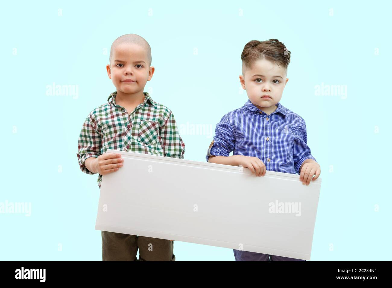 Portrait of two boys holding white sign on isolated background Stock ...