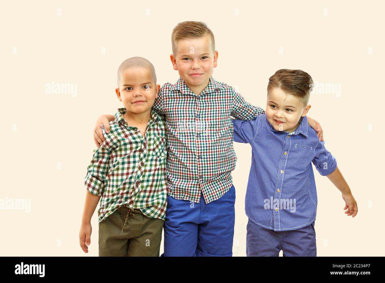 Three fashion cute boys are standing together on white isolated ...